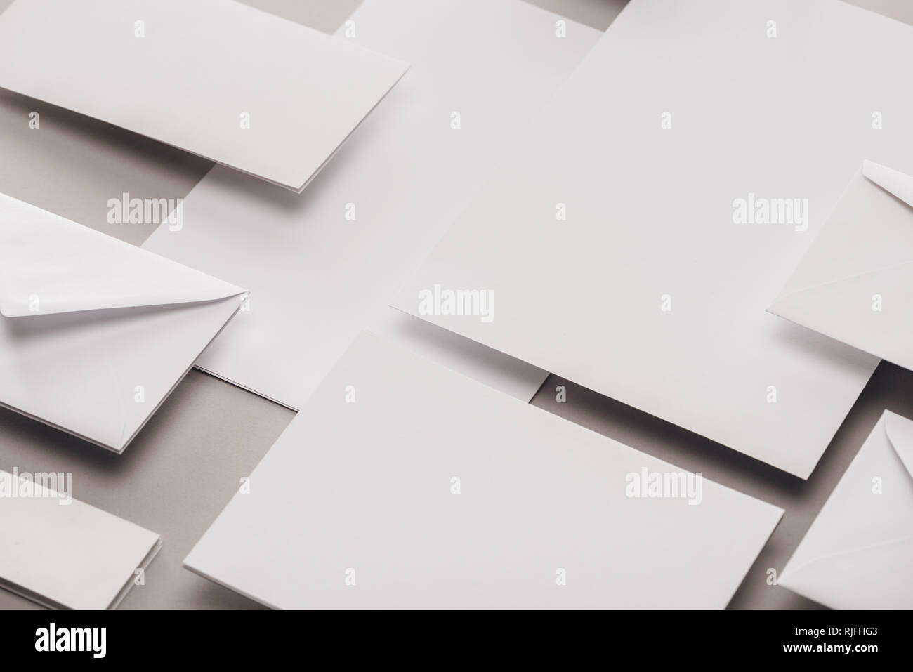 flat lay with white papers and envelopes on grey background Stock Photo ...