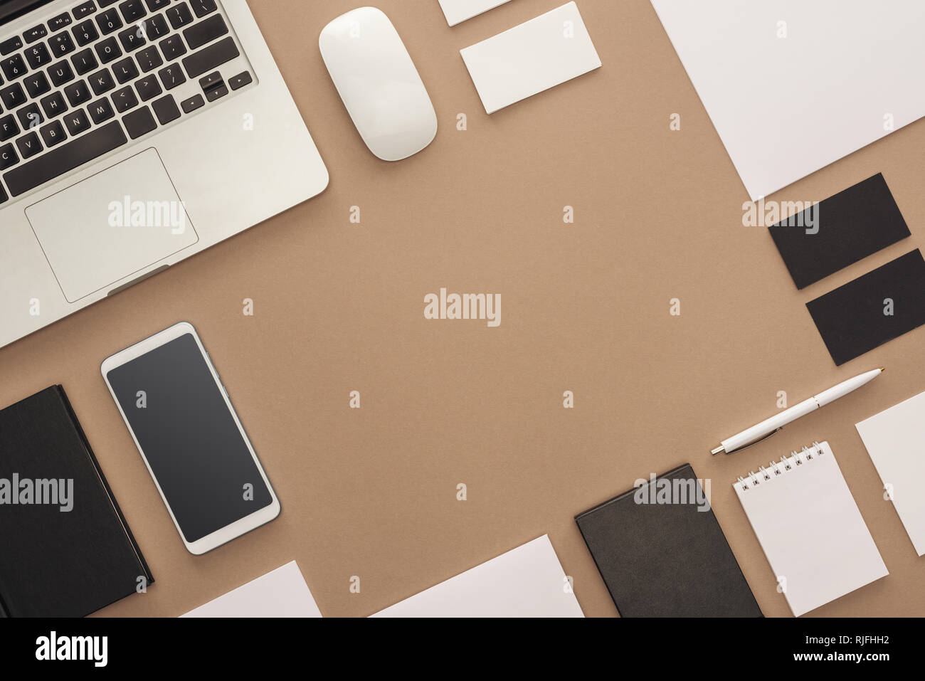 Laptop, smartphone, pen, computer mouse, cards and notebooks on beige ...