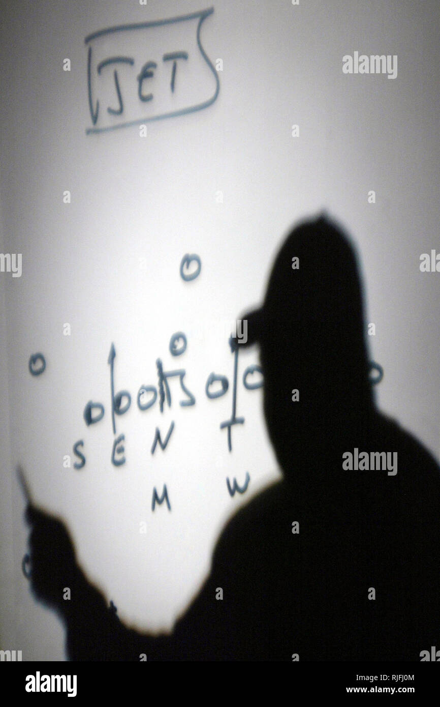 A silhouette of a coach using a grease board to go over the offensive ...