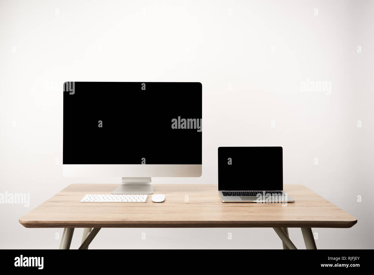 workplace with desktop computer and laptop with copy space on wooden ...
