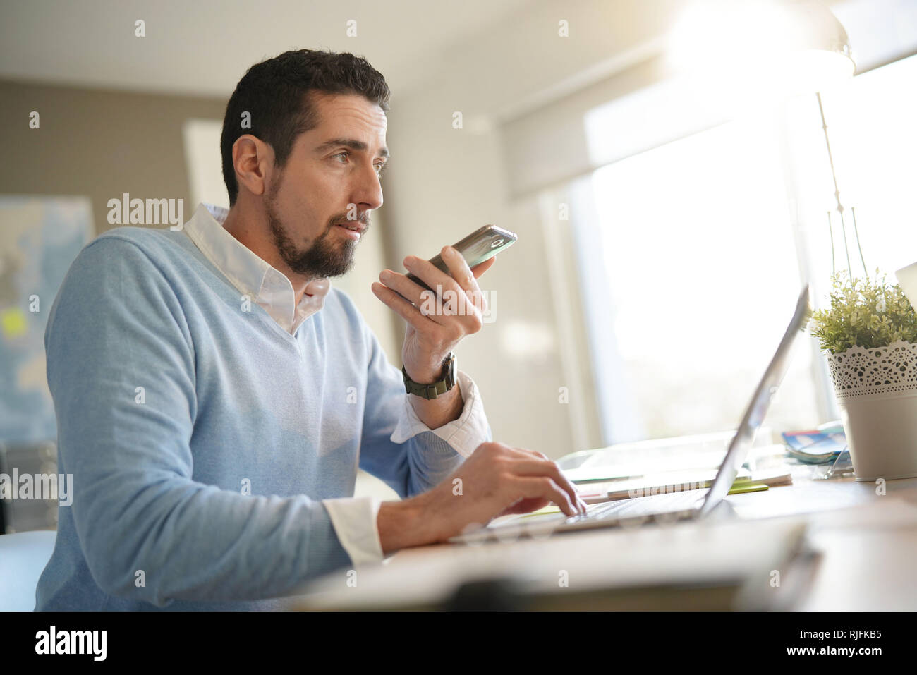 Salesman in office talking on phone Stock Photo - Alamy