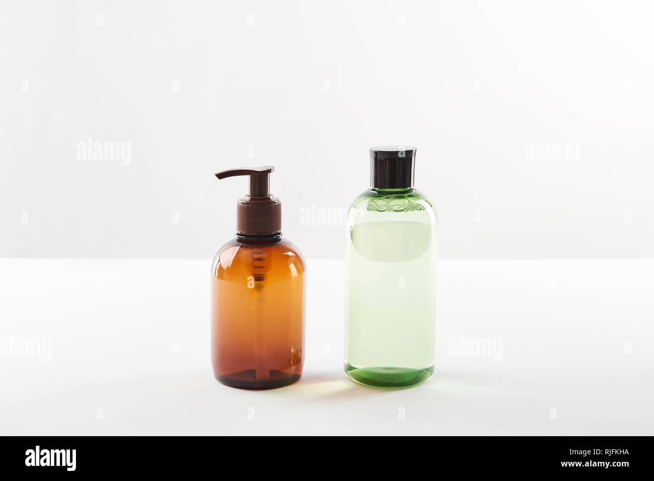 Cosmetic dispenser with lotion and bottle of serum on white surface ...