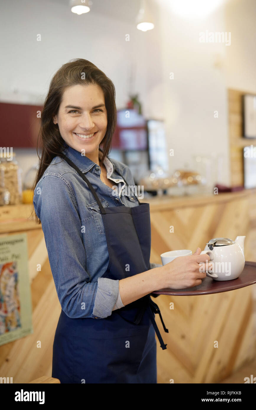 Waitress in coffee shop holding tray Stock Photo - Alamy