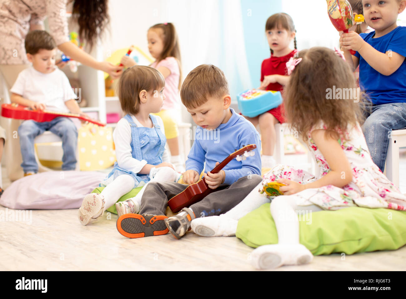 Group of kids playing musical toys. Early musical education in ...