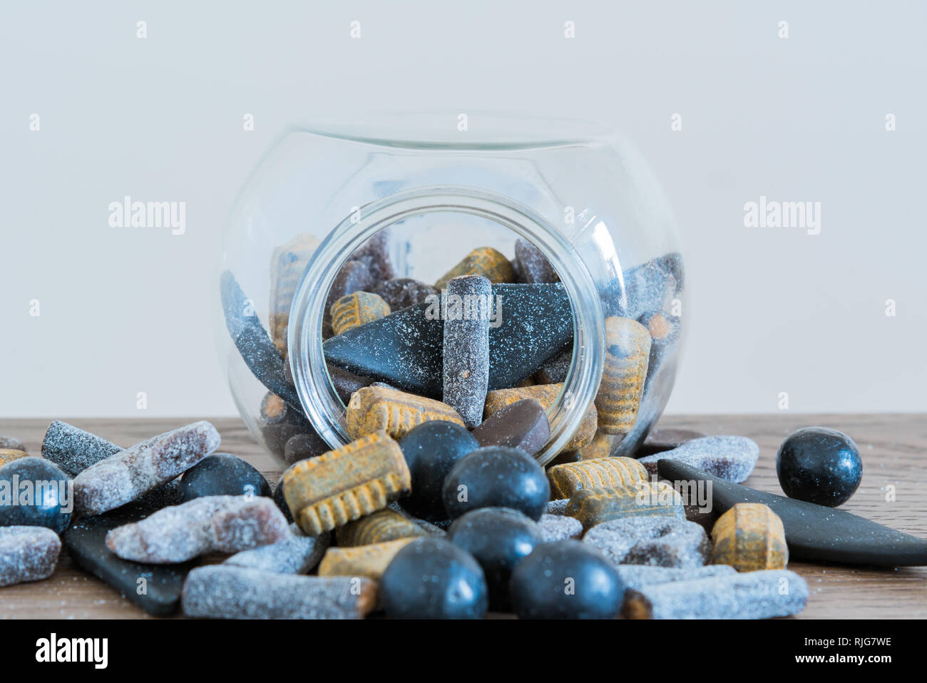 Salmiakki spilling out of open candy jar and onto table Stock Photo - Alamy