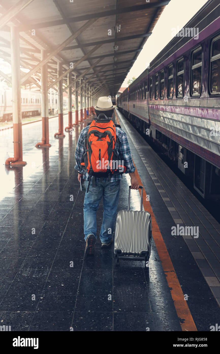 Asian traveler man with belongings waiting for travel by train Stock ...