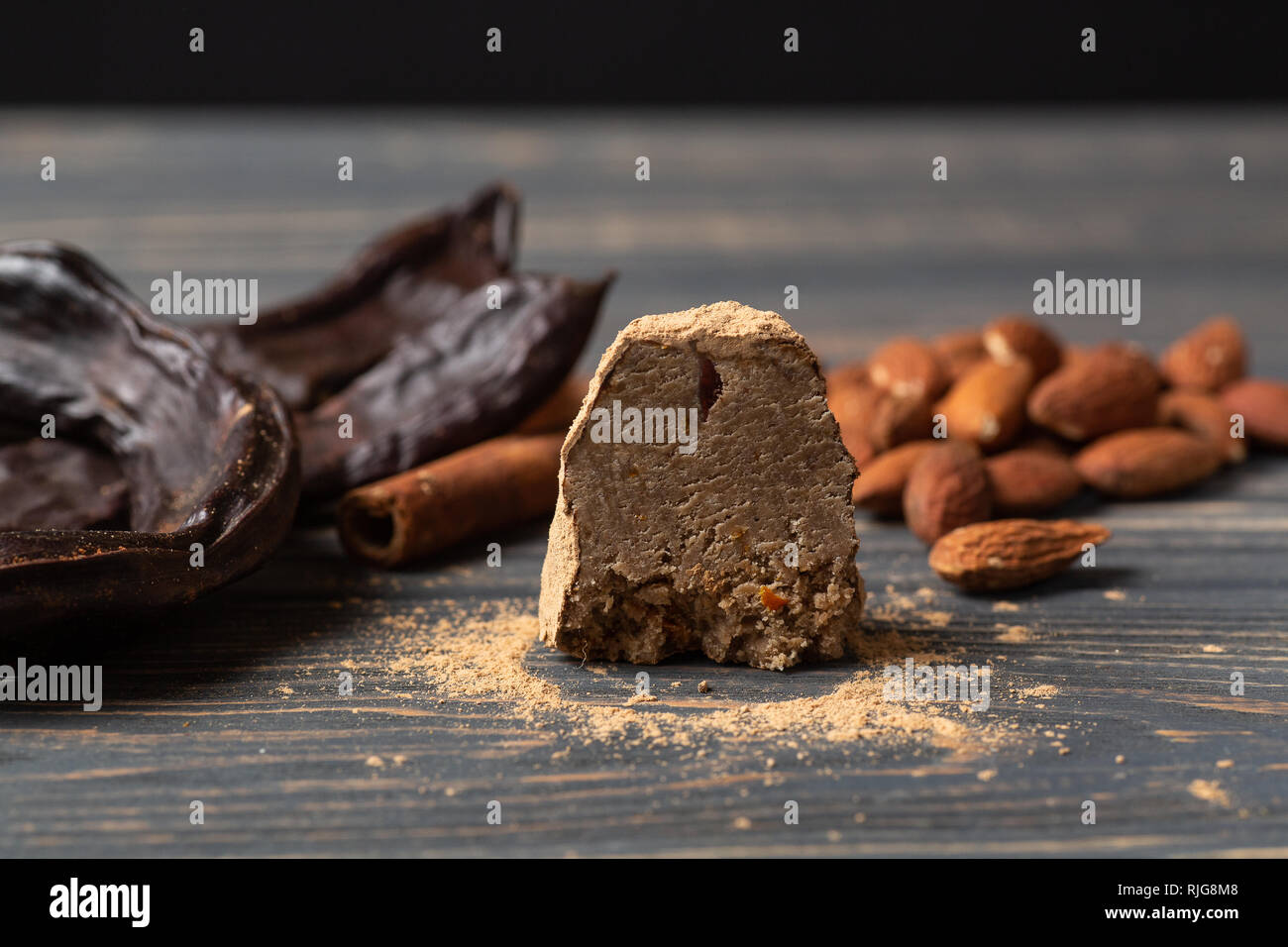 Healthy raw vegan sweet candy with carob, cinnamon and almond on wooden ...