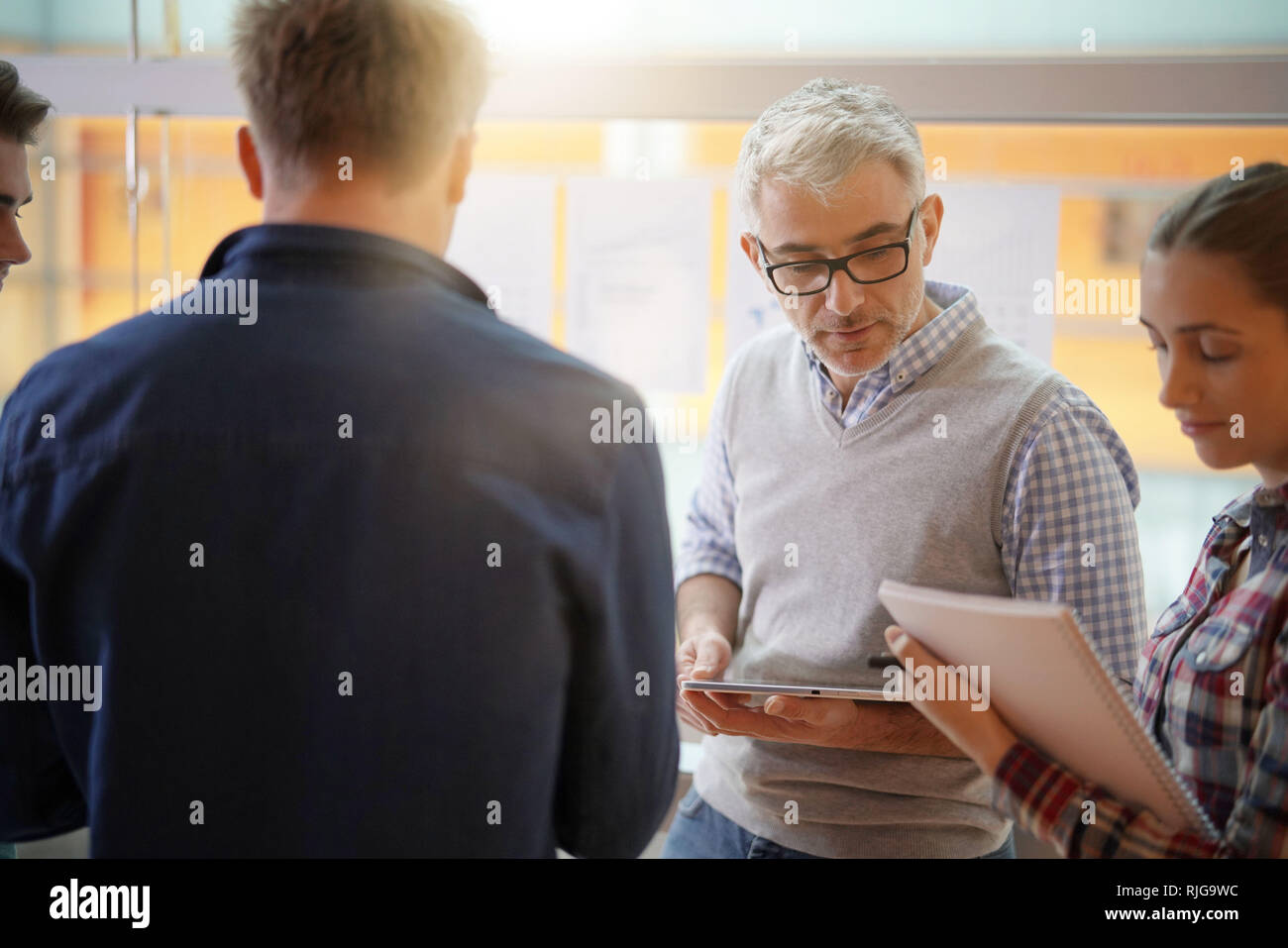 Teacher in classroom teaching economics to young people Stock Photo - Alamy