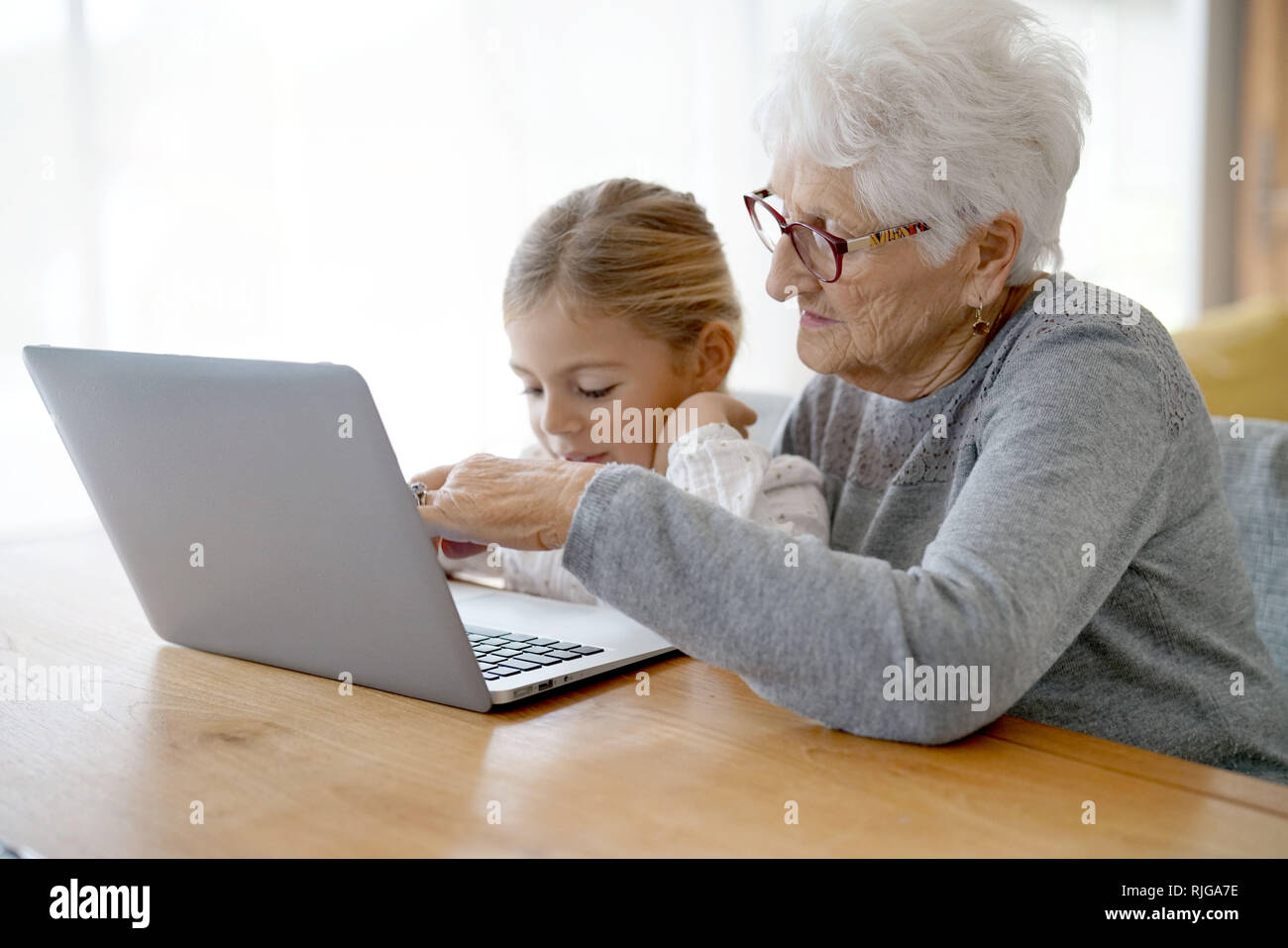 Little girl with grandmother using laptop computer Stock Photo - Alamy