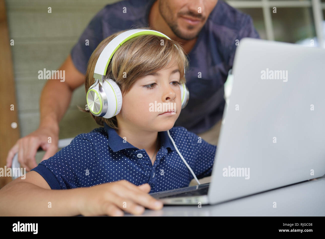 Little boy using laptop with help of daddy Stock Photo - Alamy