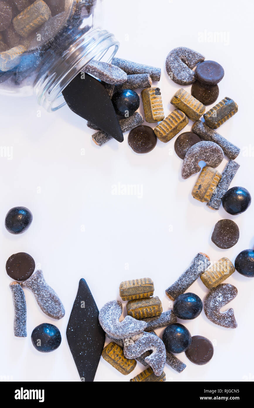 Flat-lay arrangement of variety of double salted licorice spilling from ...