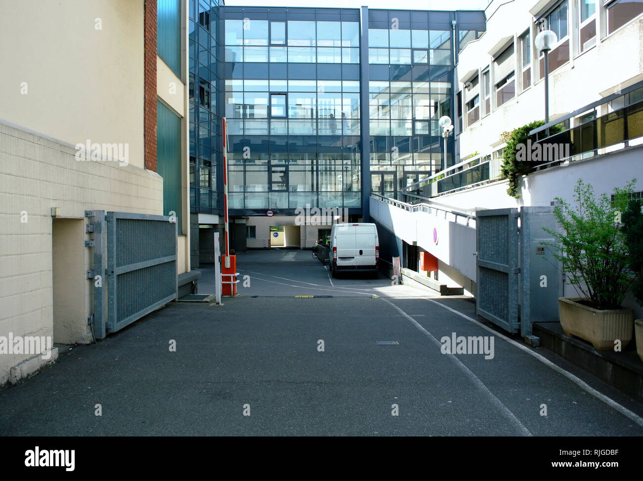 Interior courtyard of a modern building with glass facade and car ...