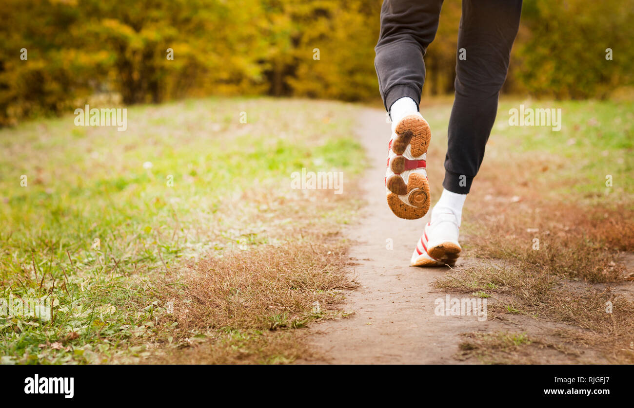 running along a park path, healthcare and problem concept - close-up of ...