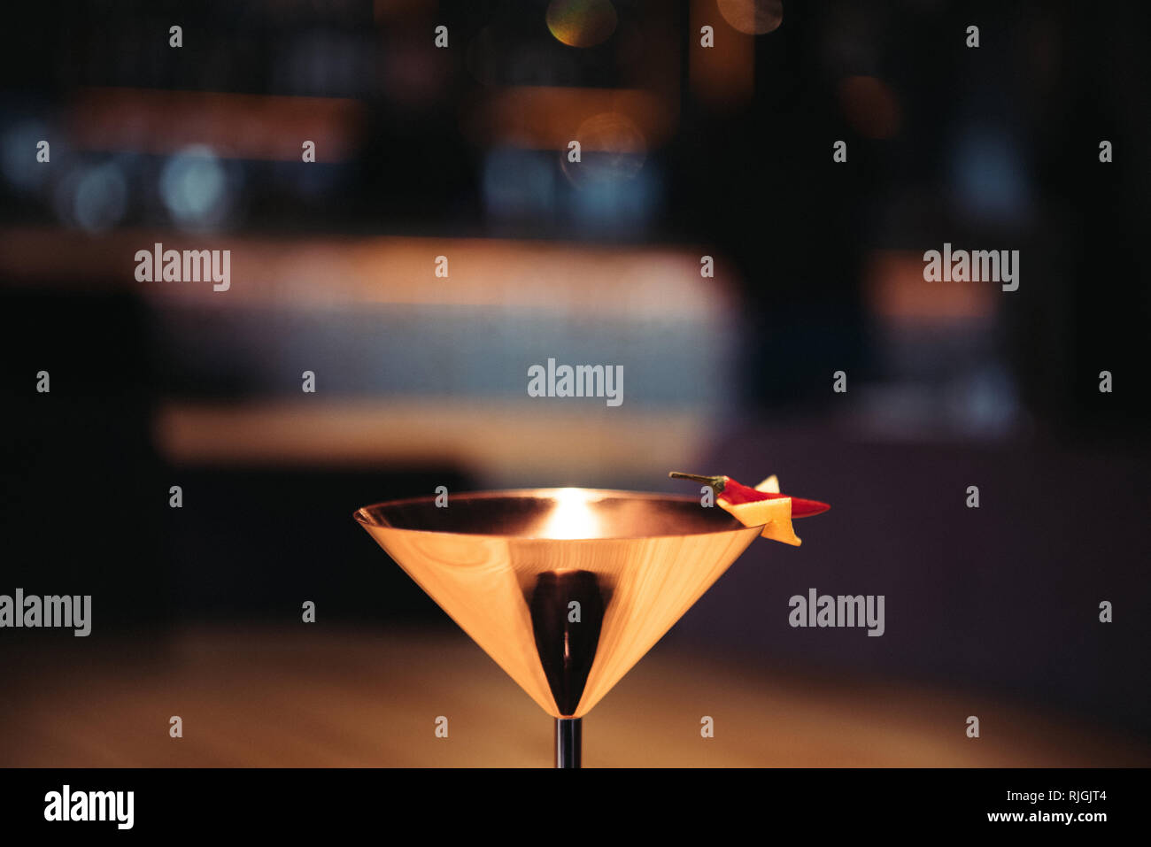 alcoholic cocktail in metal glass decorated with chili pepper and nacho ...