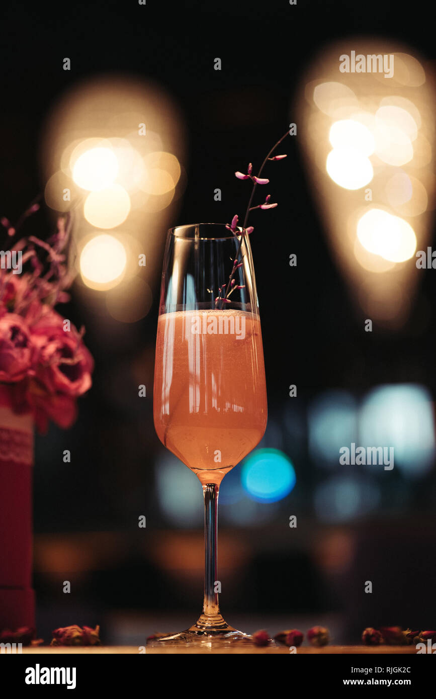 selective focus of pink alcoholic cocktail decorated with dry flowers ...