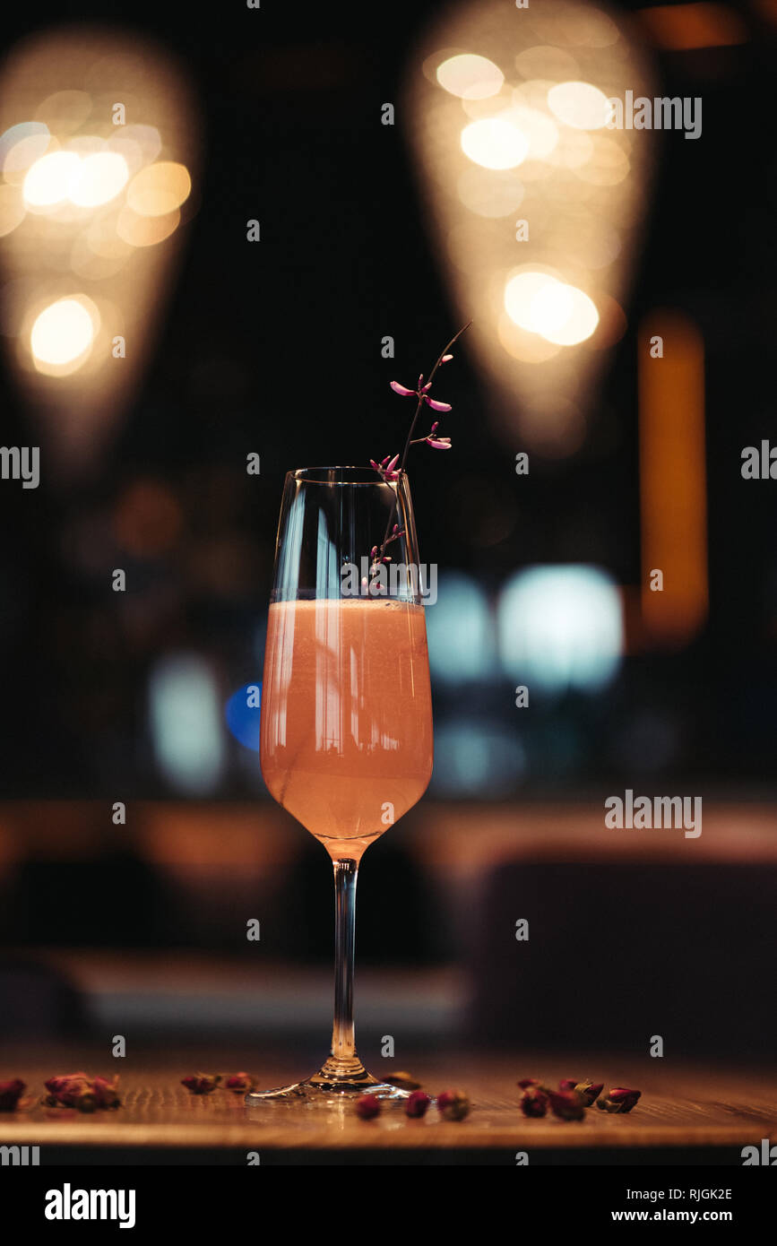 selective focus of pink alcoholic cocktail decorated with dry flowers ...