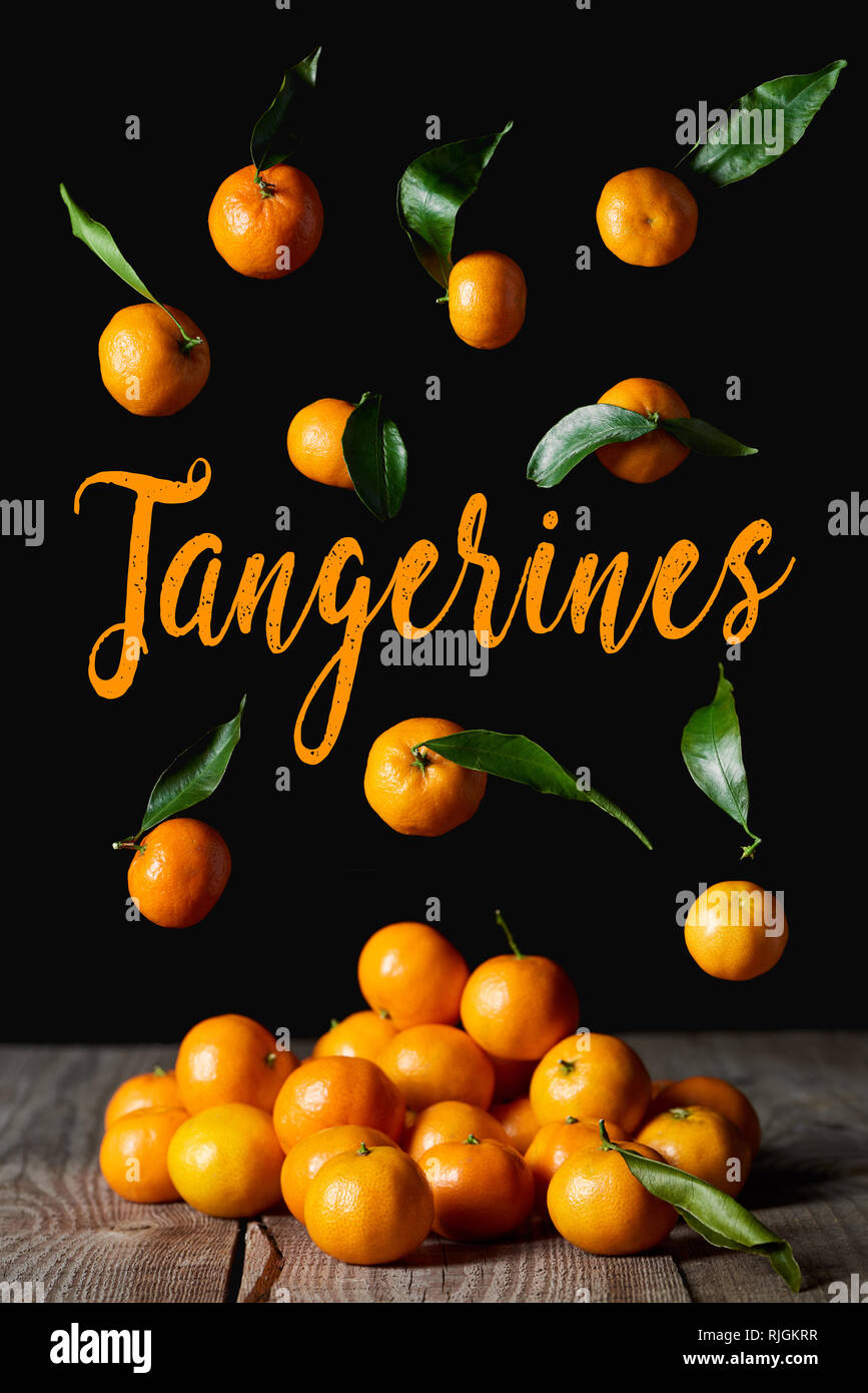 organic tangerines with green leaves isolated on black Stock Photo - Alamy