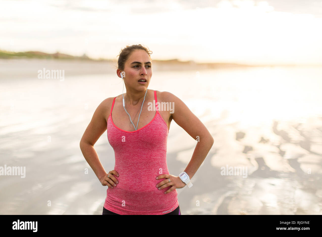 Female runner recovering after running on a beach at sunrise Stock ...