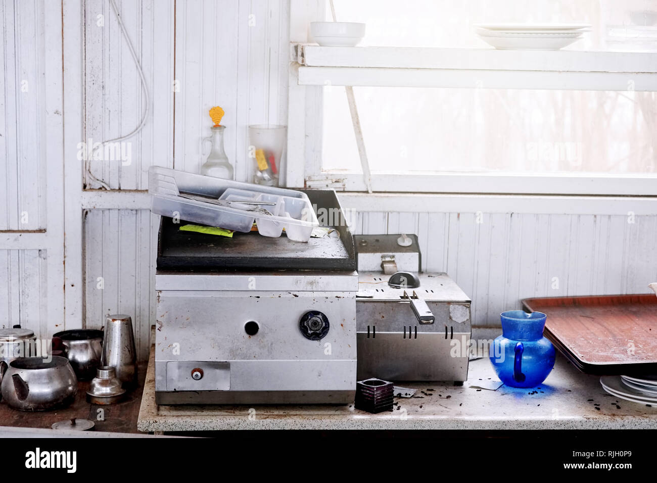 Industrial kitchenware over the counter of an abandoned and ruined ...