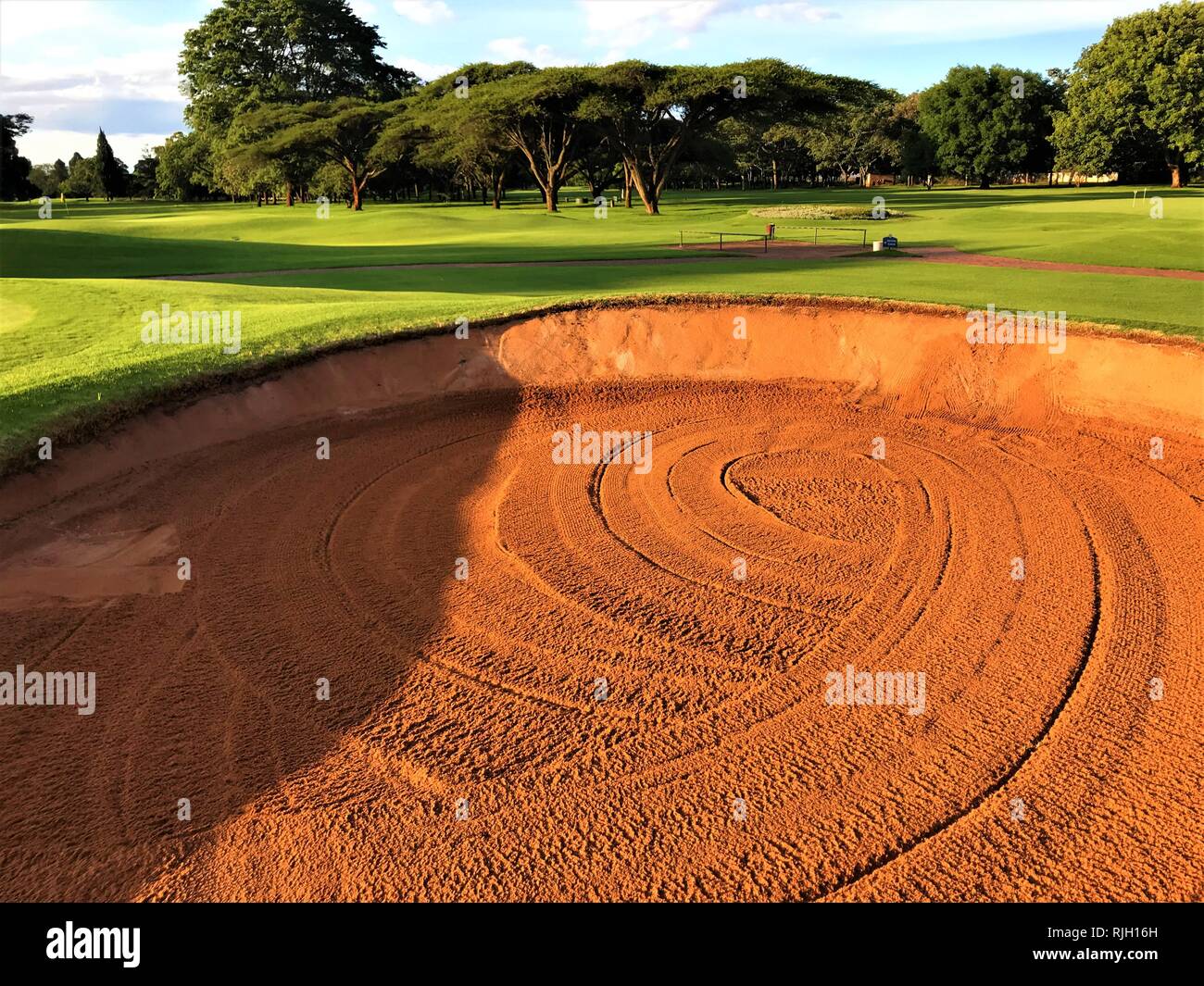 Beautiful golf course with sand bunker and flag in hole on putting ...