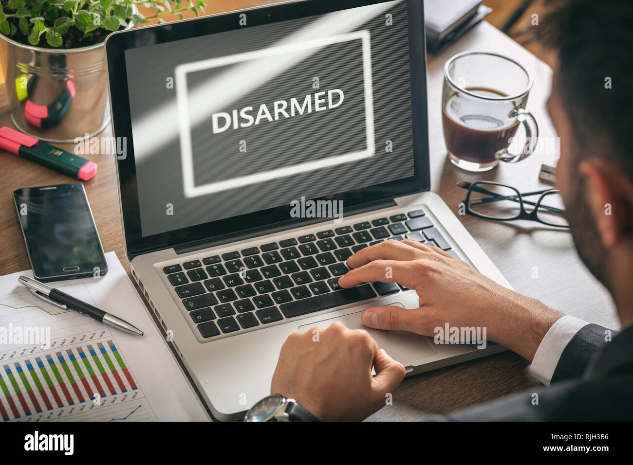 Disarmed concept. Man working with a computer, disarmed text on the ...