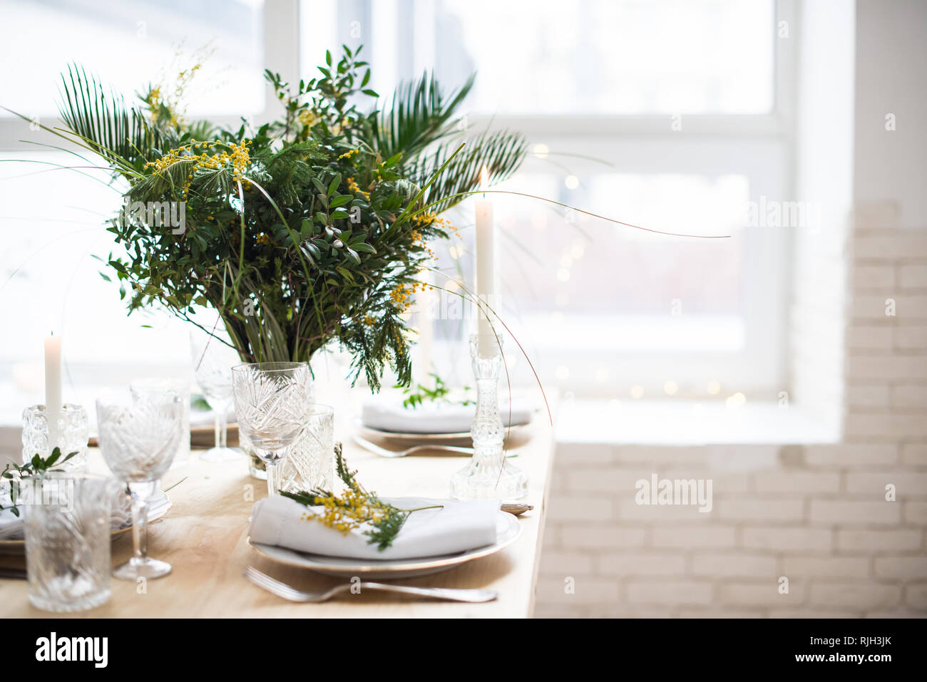 Beautiful springtime table setting with green leaves and mimosa ...