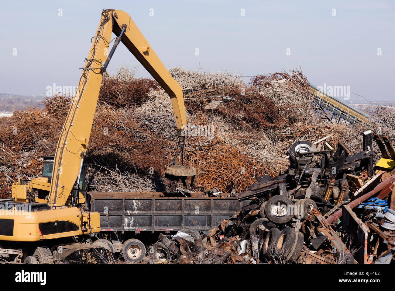 Excavator Moving Scrap Metal with Electro Magnet Stock Photo - Alamy