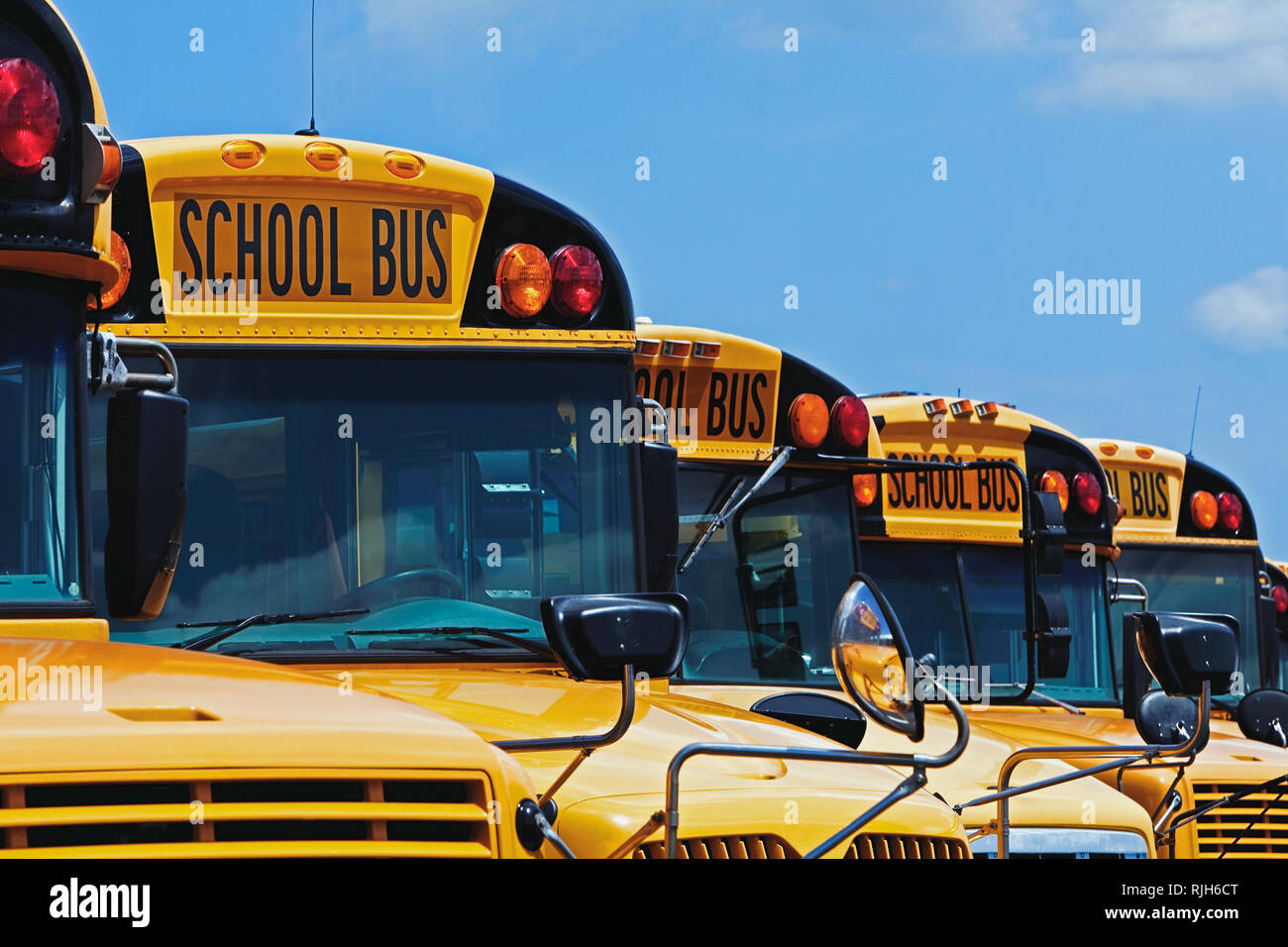 Yellow school buses parked diagonally Stock Photo - Alamy