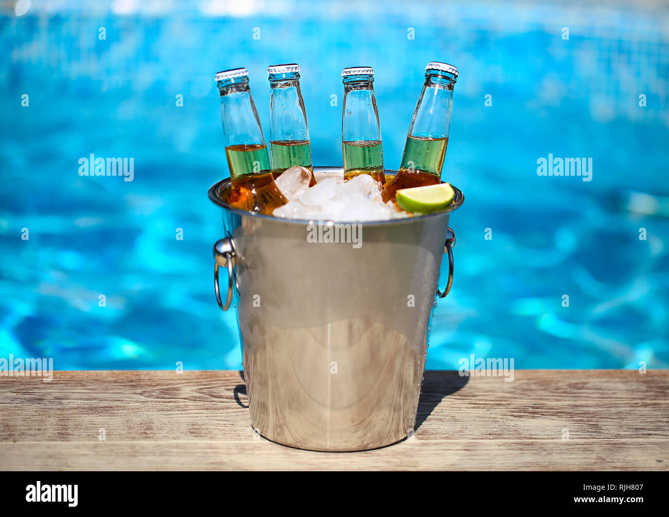 Closeup view of bucket with ice cubes, beer bottles and lime slices by ...
