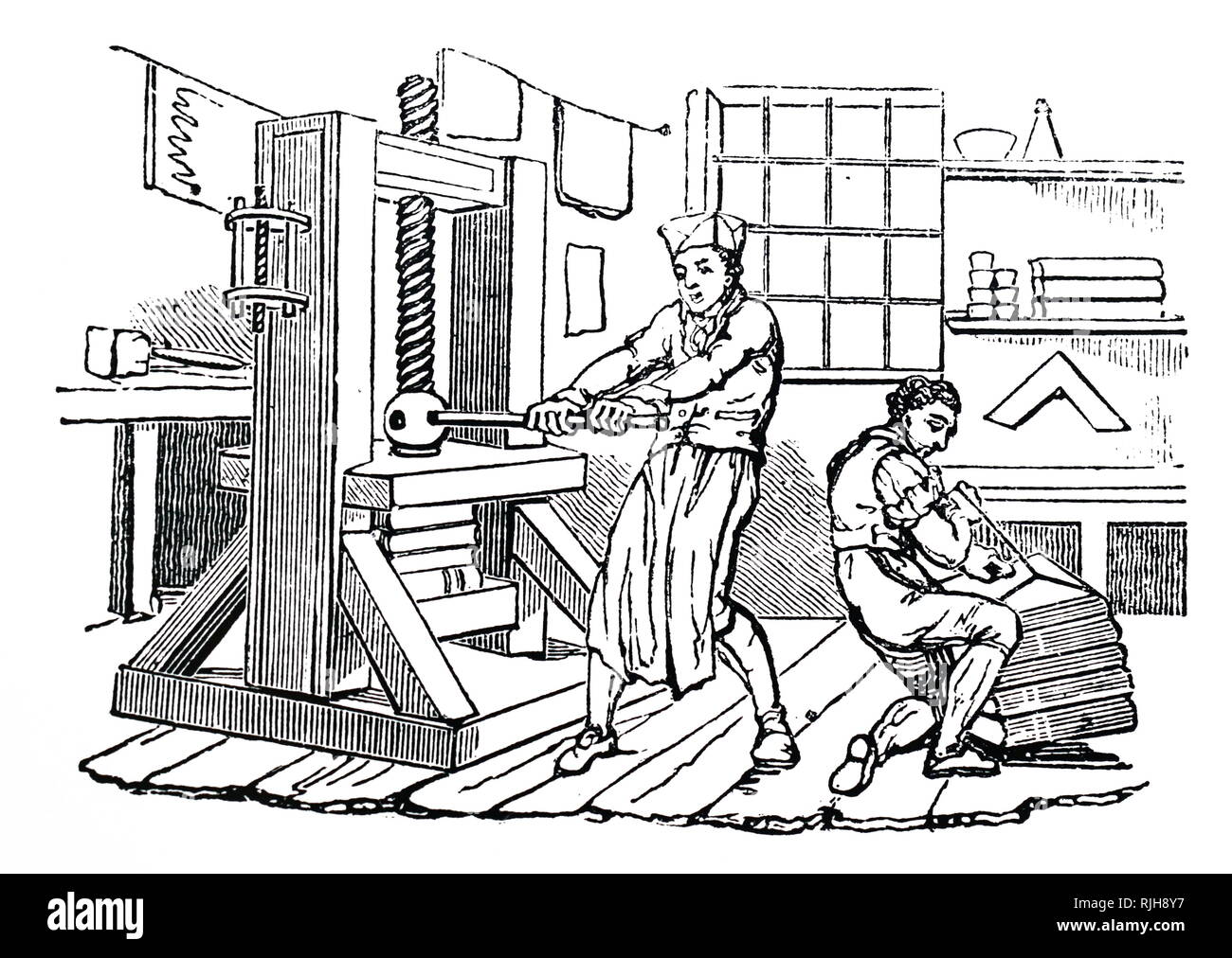 A woodcut engraving depicting a standing screw press being used in a ...