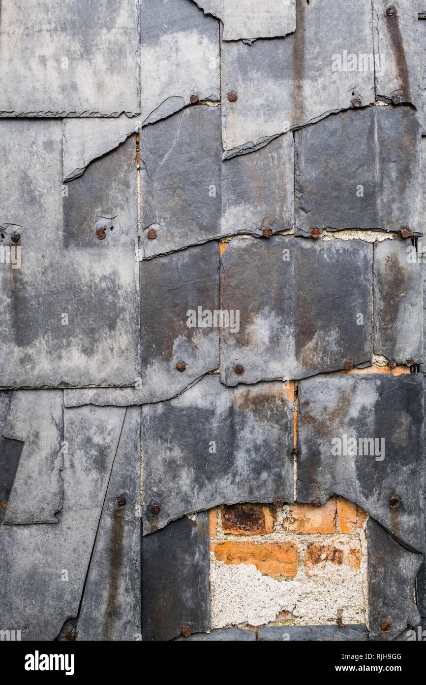 Old and damaged Slate cladding on the exterior of brick built houses ...