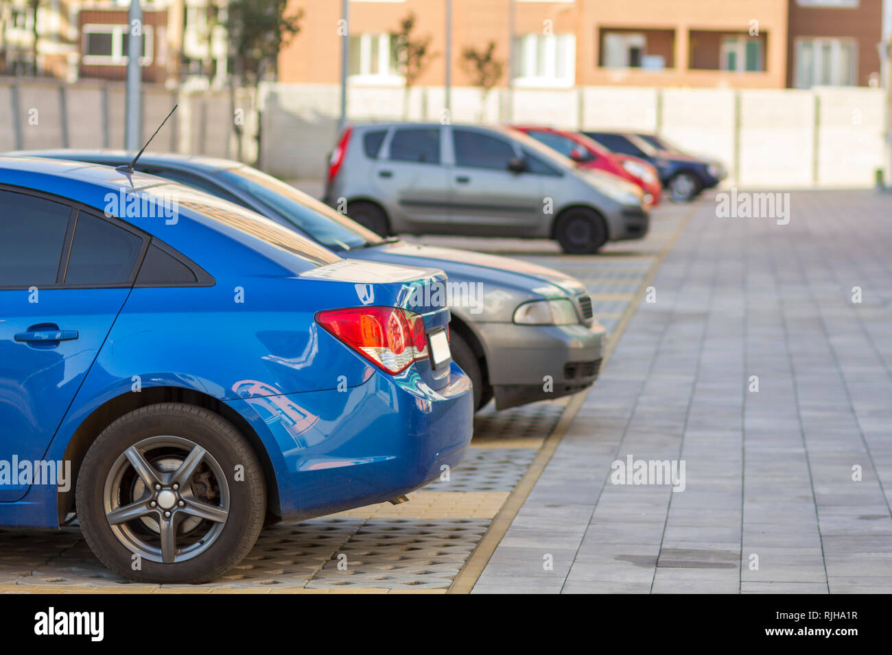 Side view detail of cars row parked in paved yard parking lot area on ...