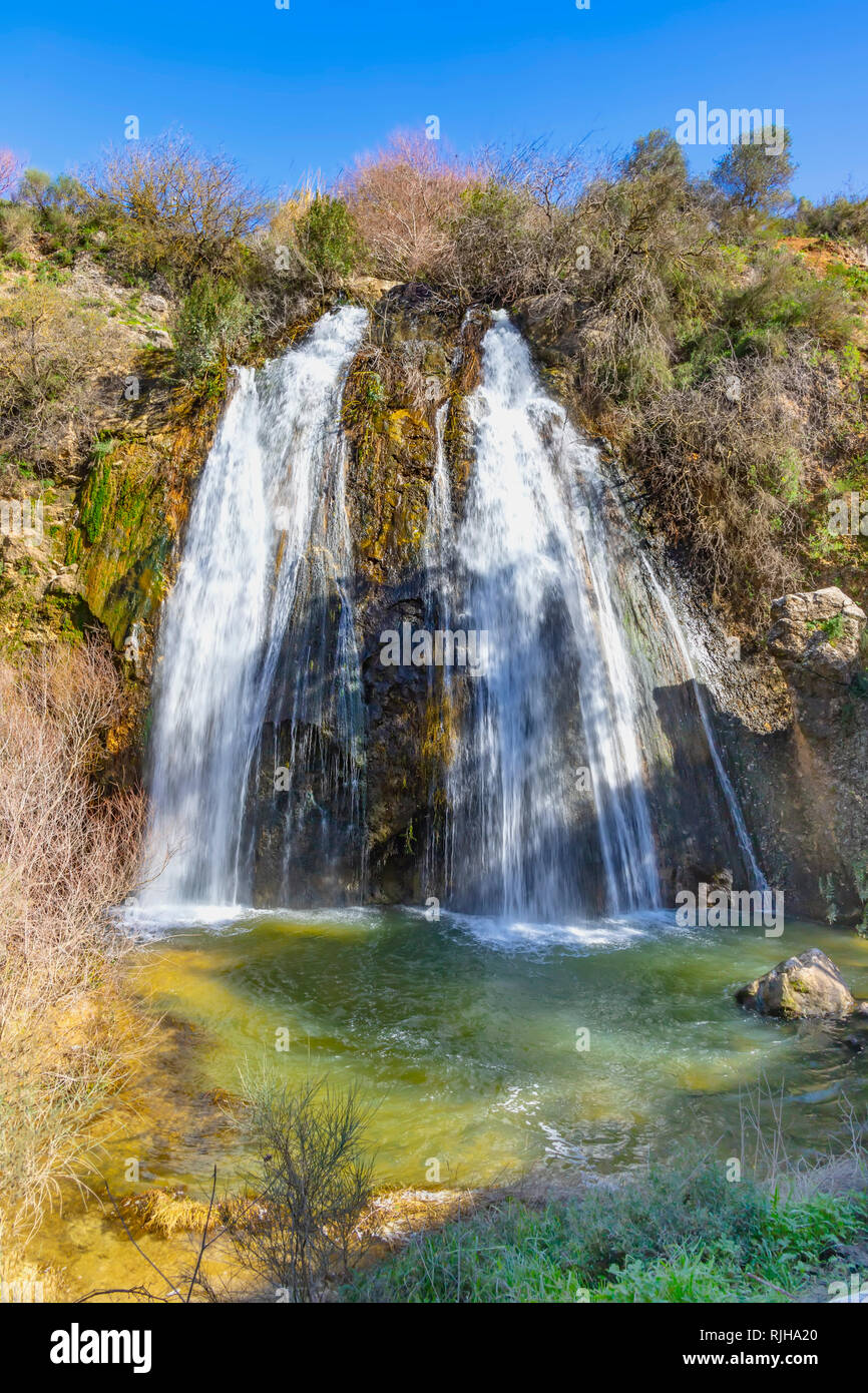 Front view of the waterfall and the pond in front of it among the ...