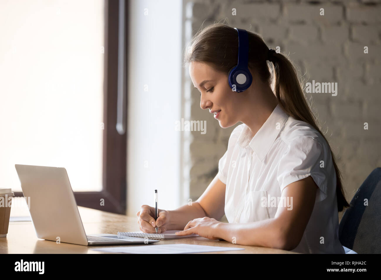 Focused female in headphones make notes taking online course Stock ...