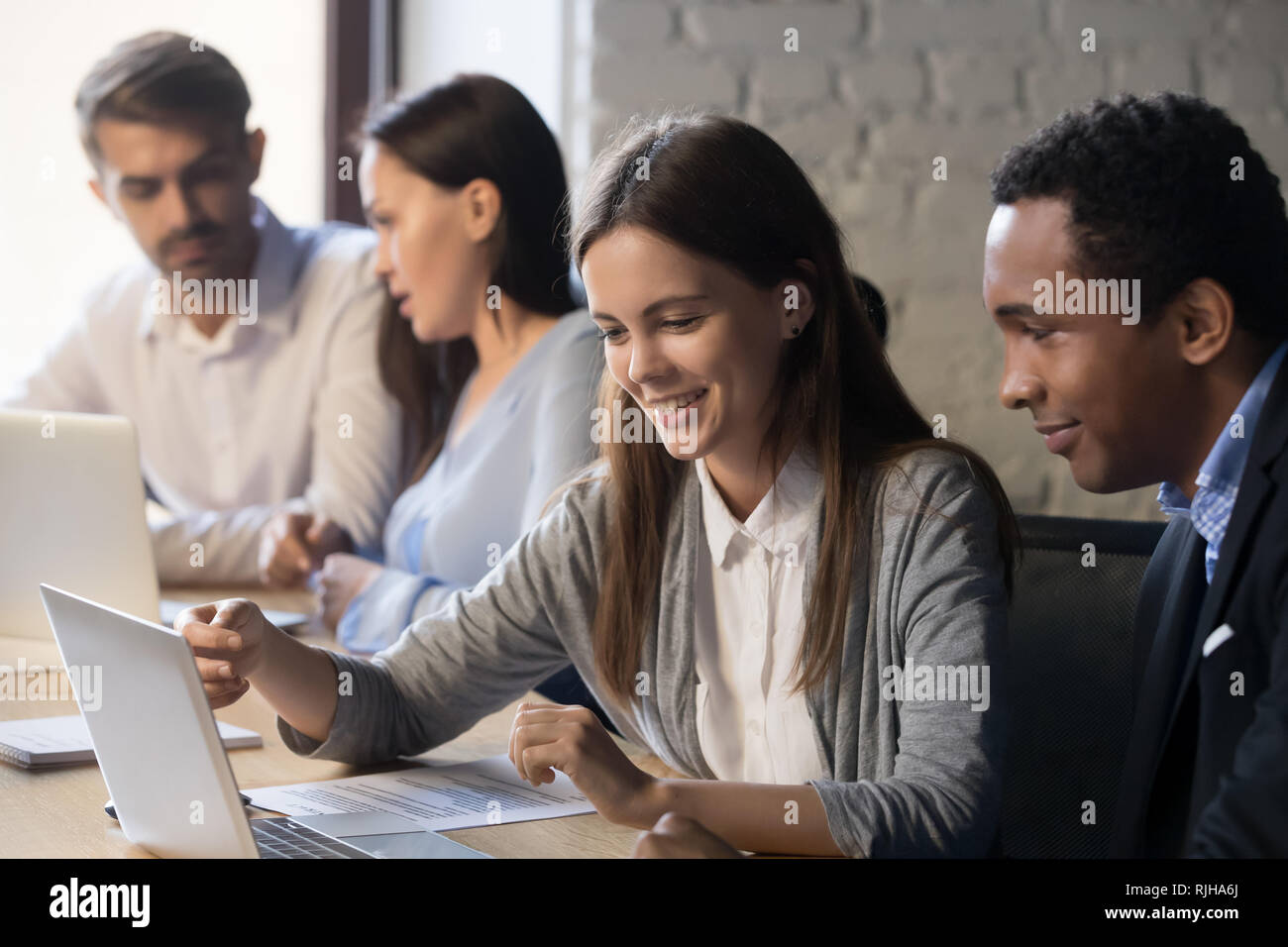 Diverse employees work together cooperating in office Stock Photo - Alamy