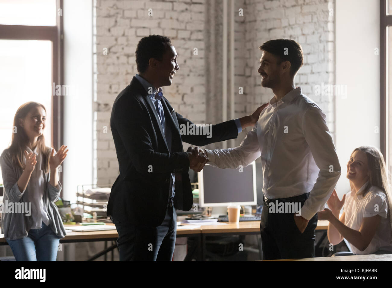 Excited black boss handshake male employee greeting with success Stock ...