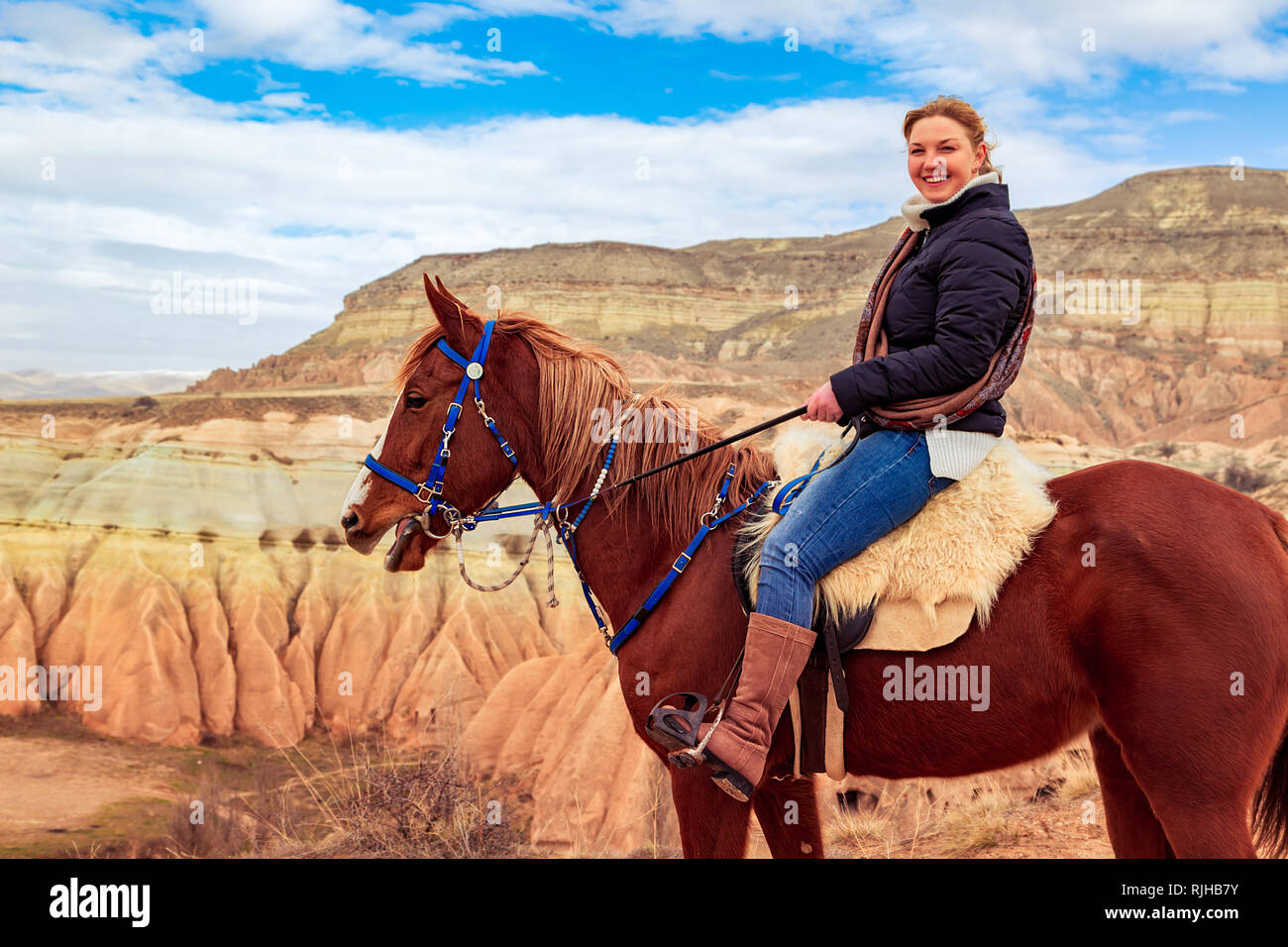 Girl riding a horse in the valley of Cappadocia. Magnificent mountain ...