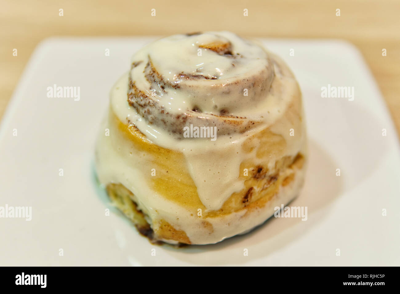 Cinnamon bun on a white plate, selective focus Stock Photo - Alamy