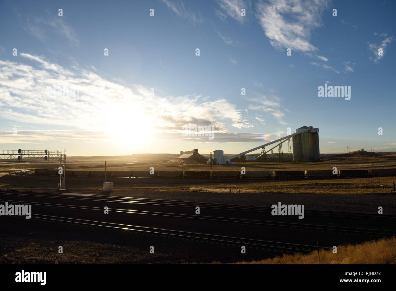 Industrial coal silo and train loading facilities at sunset in the ...