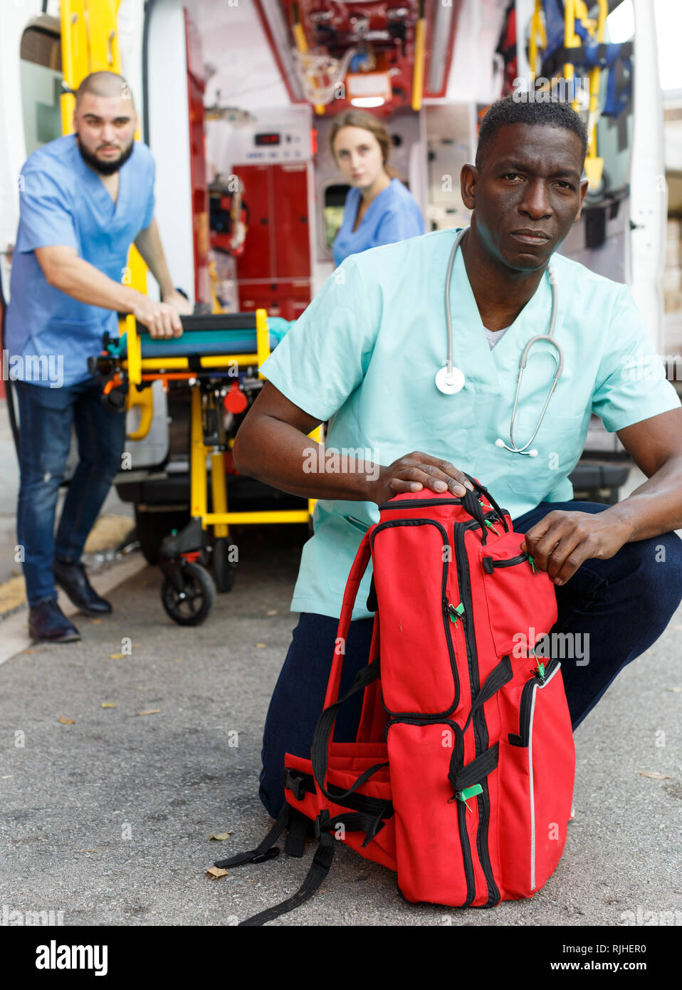 Emergency doctors with first aid kit going to call from ambulance car ...
