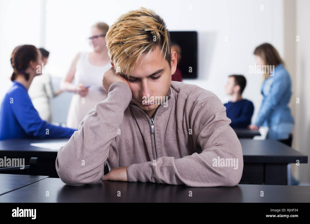 Unhappy boy student feeling uncomfortable at break between classes ...