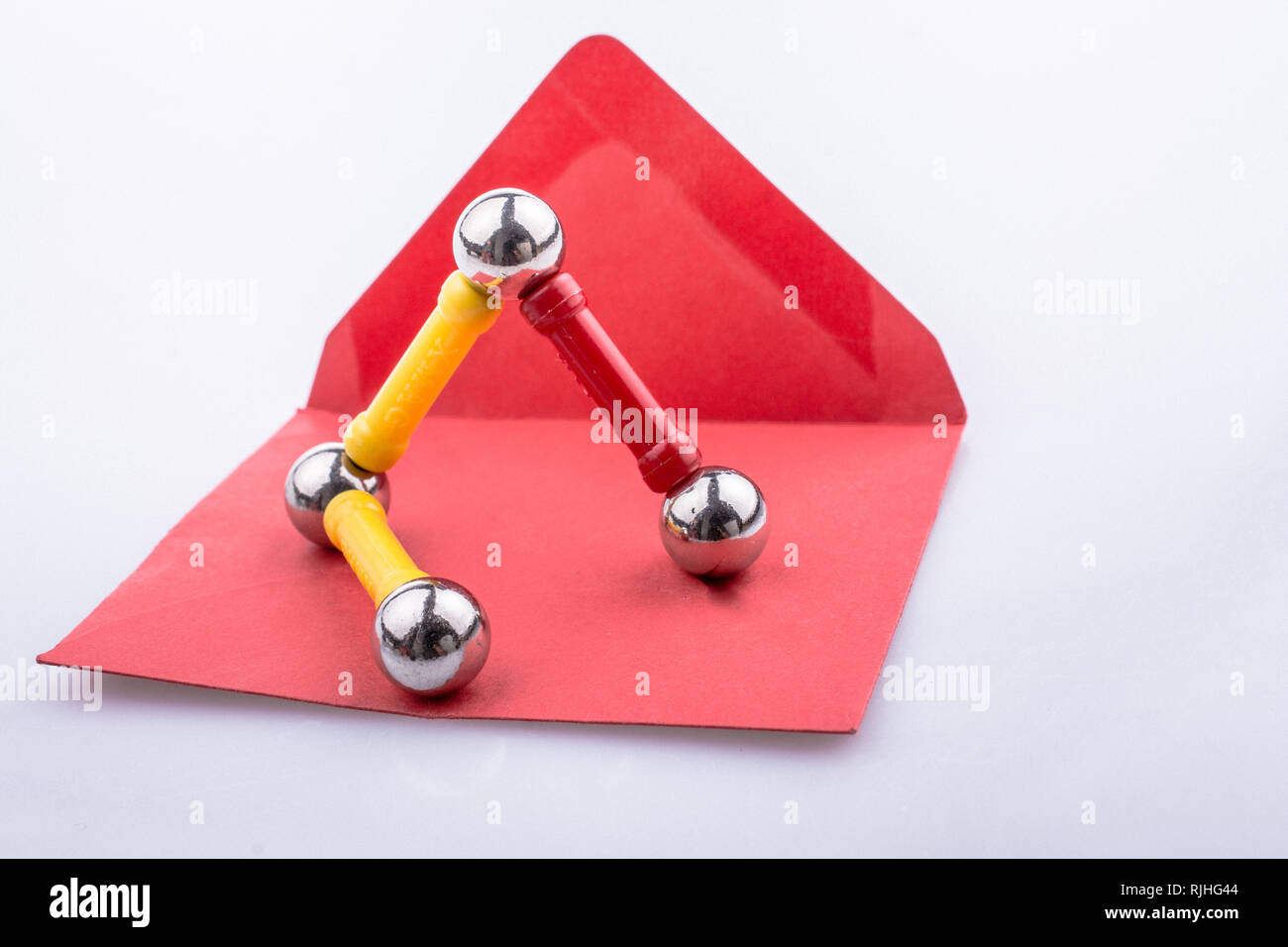 Magnet toy bars and magnetic balls on red envelope Stock Photo - Alamy