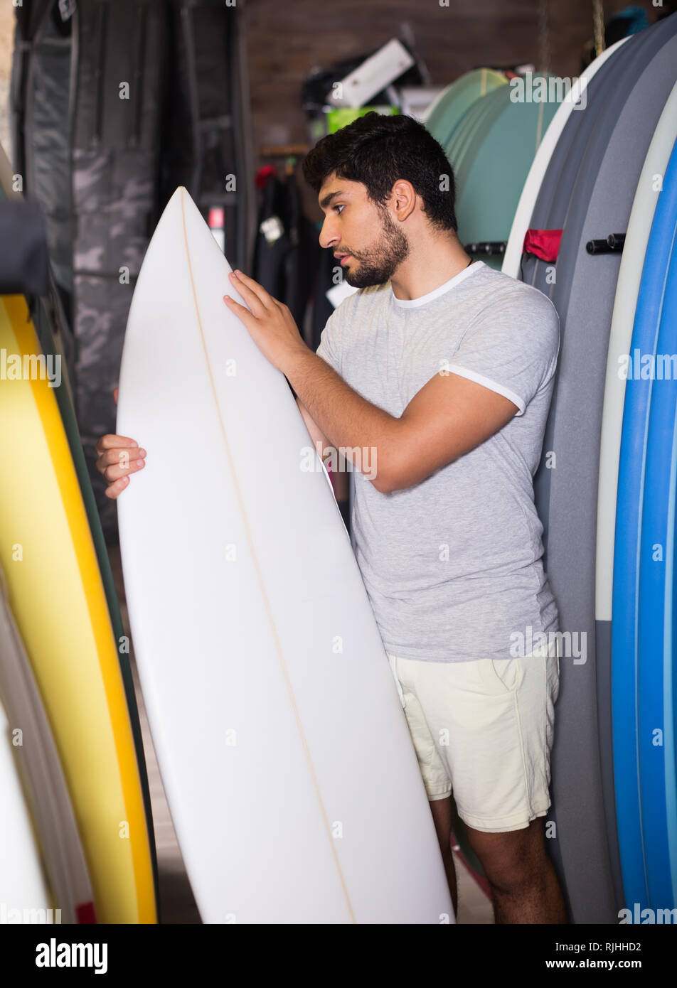portrait of professional male shopping board for surfing in the shop ...