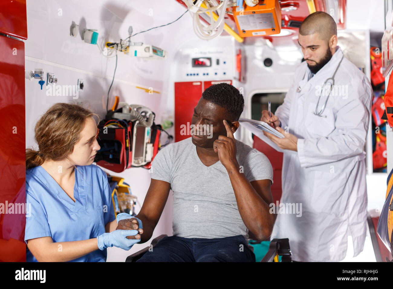 Paramedic team providing first aid to man in ambulance auto Stock Photo ...
