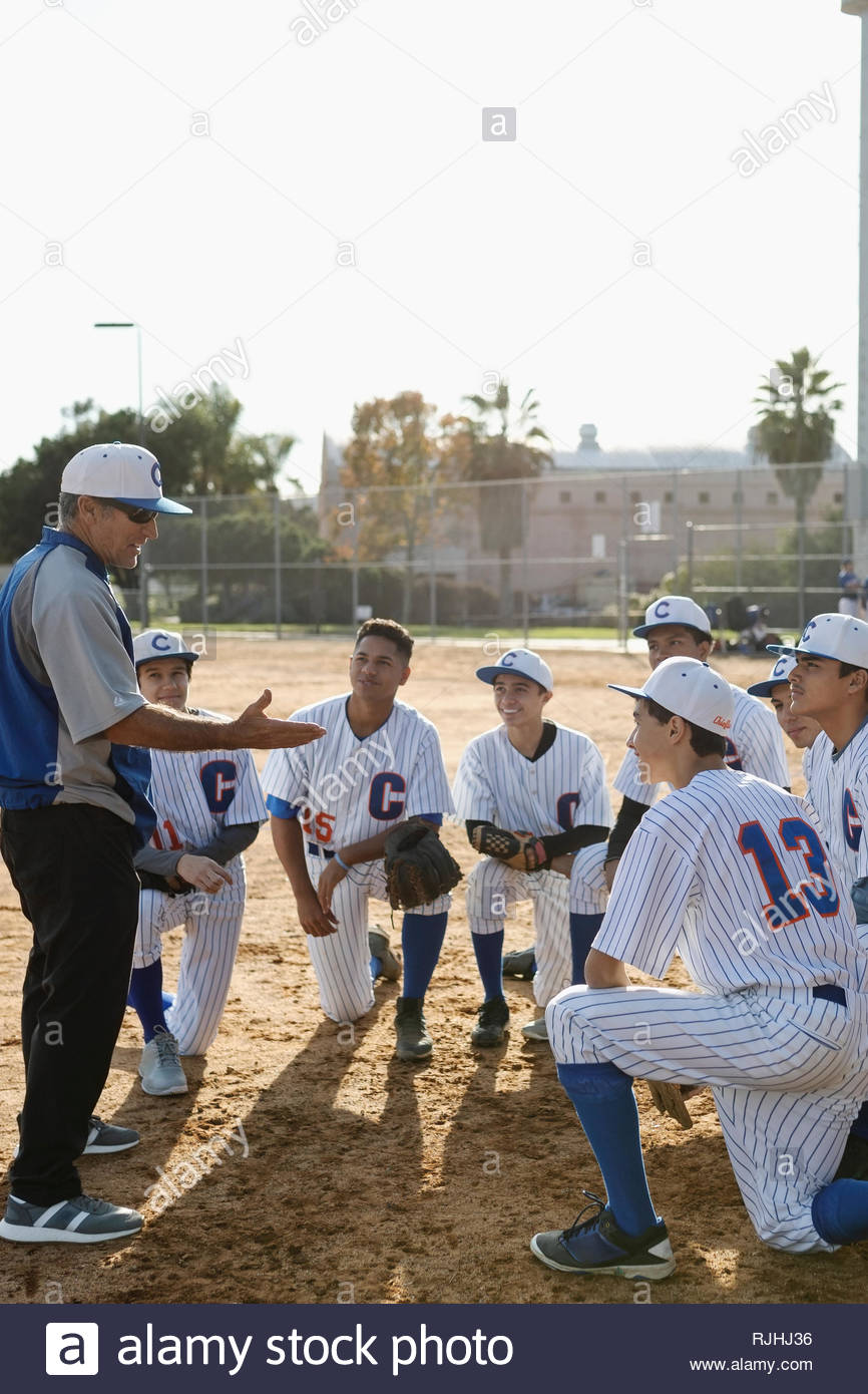 Coach and baseball players in huddle on field Stock Photo - Alamy