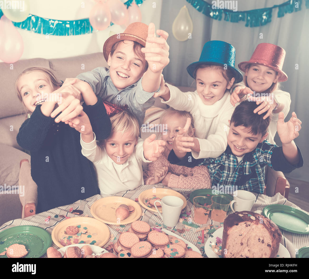 Cheerful group of children having fun during friend’s birthday party at ...