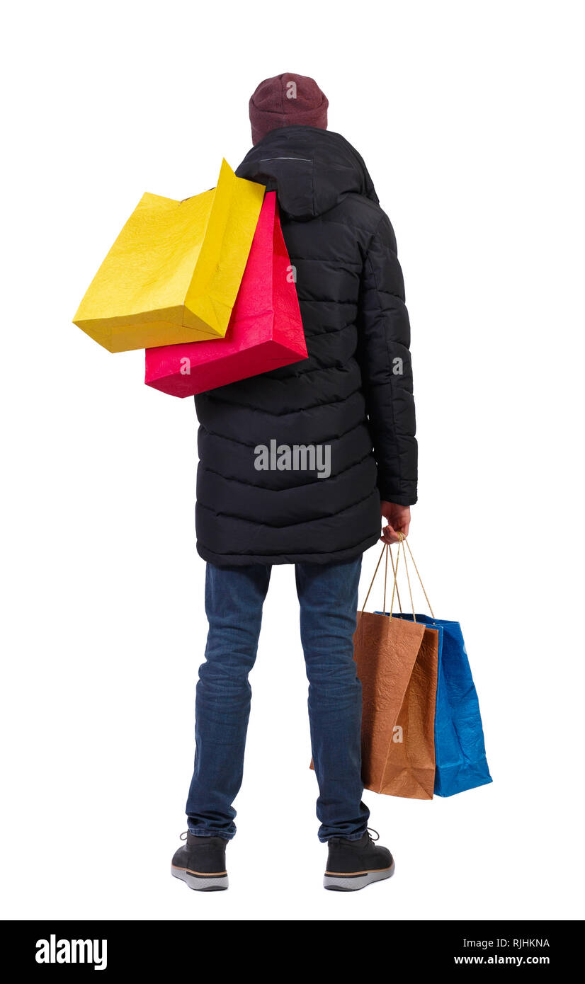 back view of man in winter jacket with shopping bags. backside view of ...