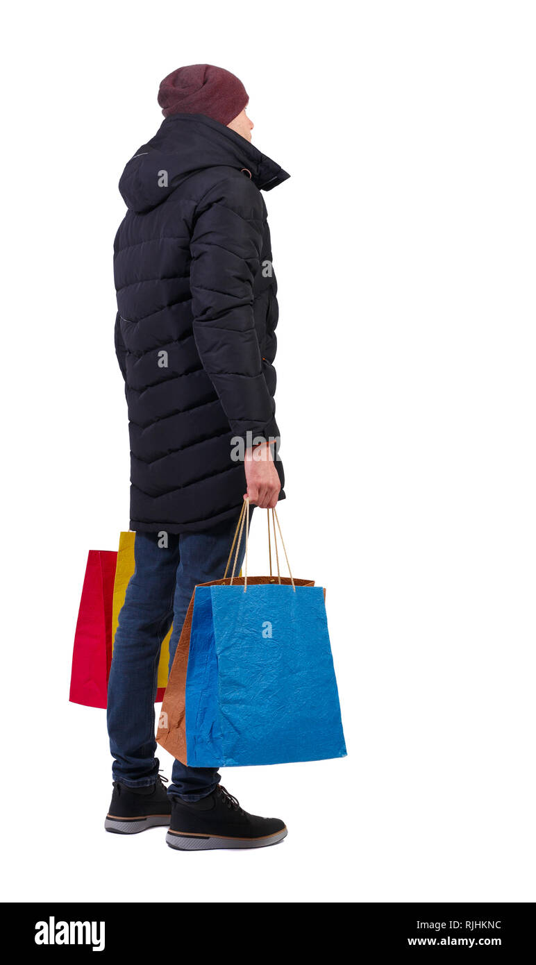 back view of man in winter jacket with shopping bags. backside view of ...