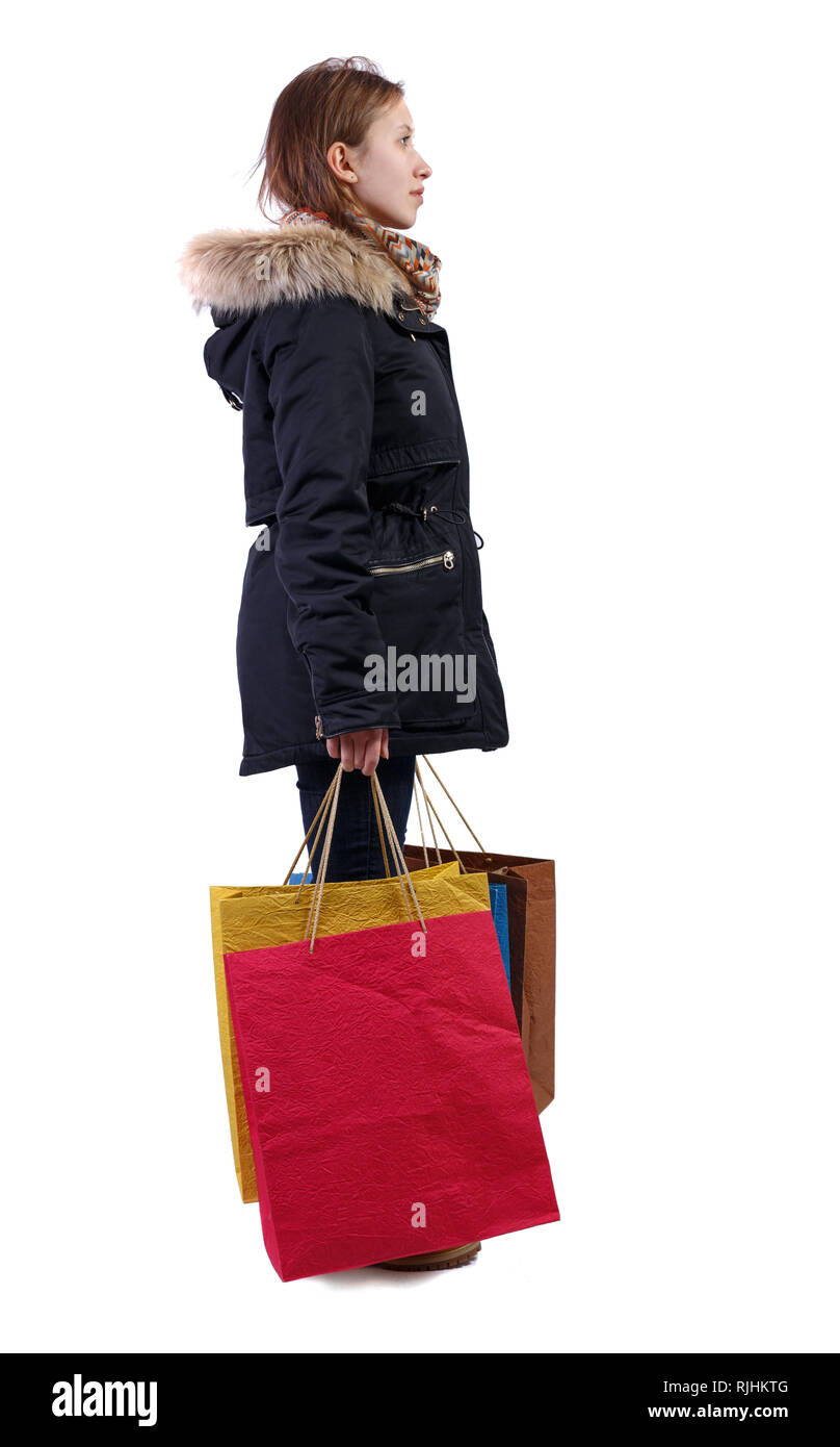 Side view of woman in winter jacket with shopping bags. backside view ...