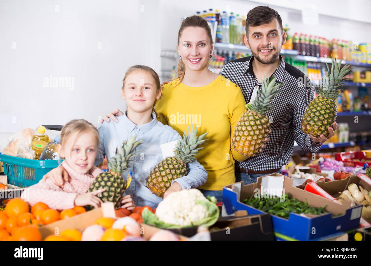 Cheerful family buyers during family shopping in vegetable department ...
